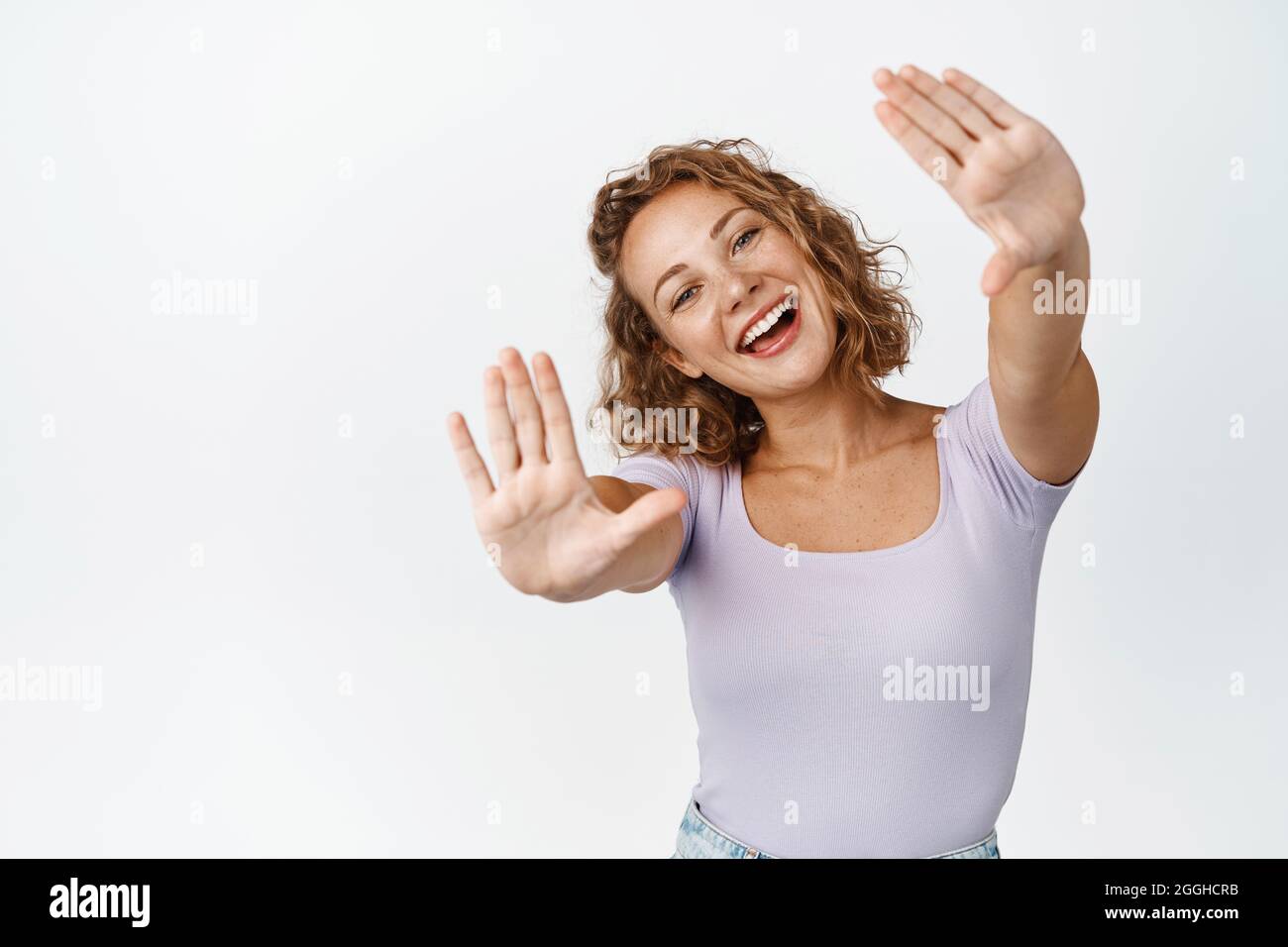 Beautiful blond girl imaging something, stretching out hands in free ...