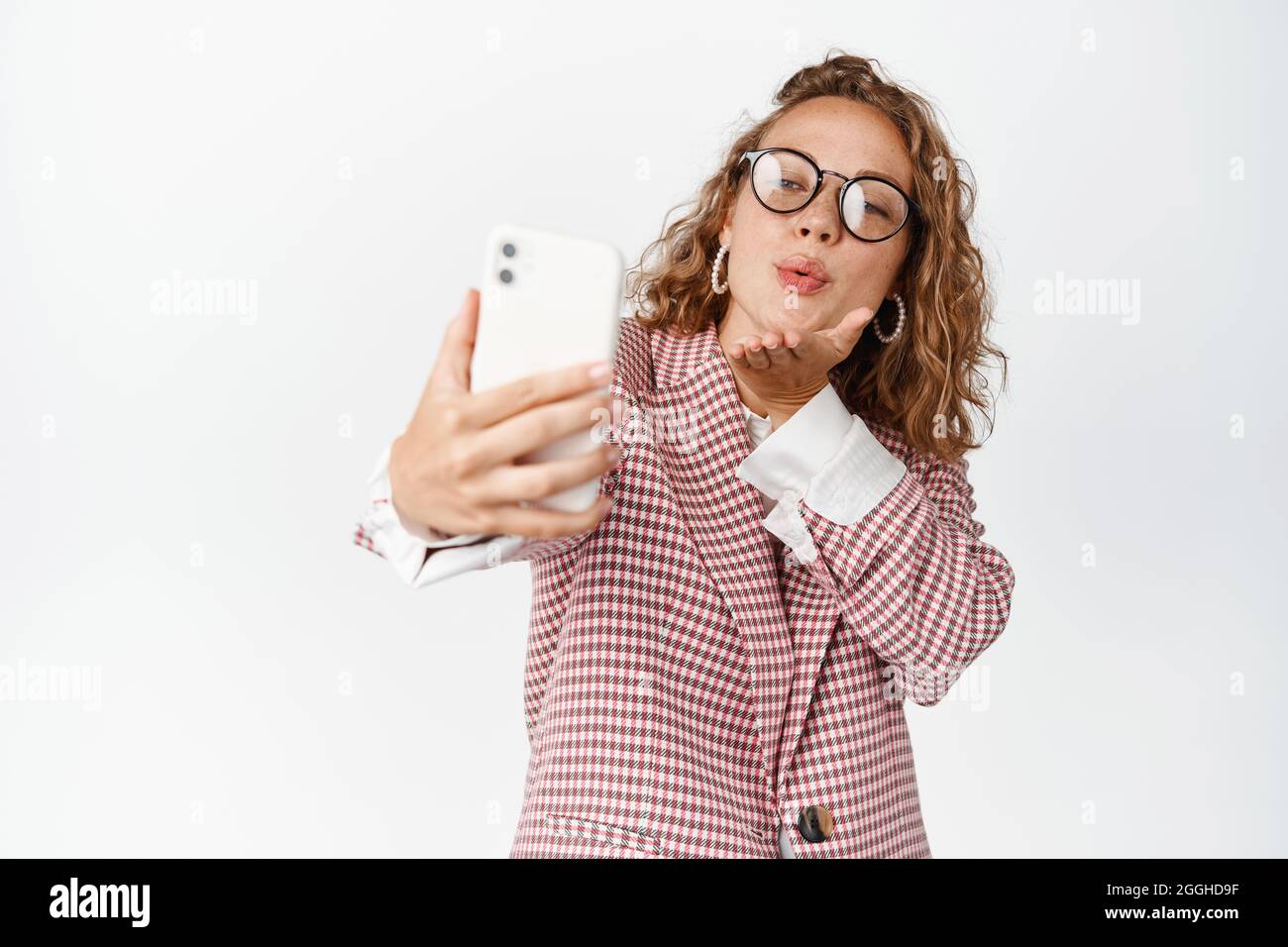 Cute female manager taking selfie, sending kisses at mobile phone ...
