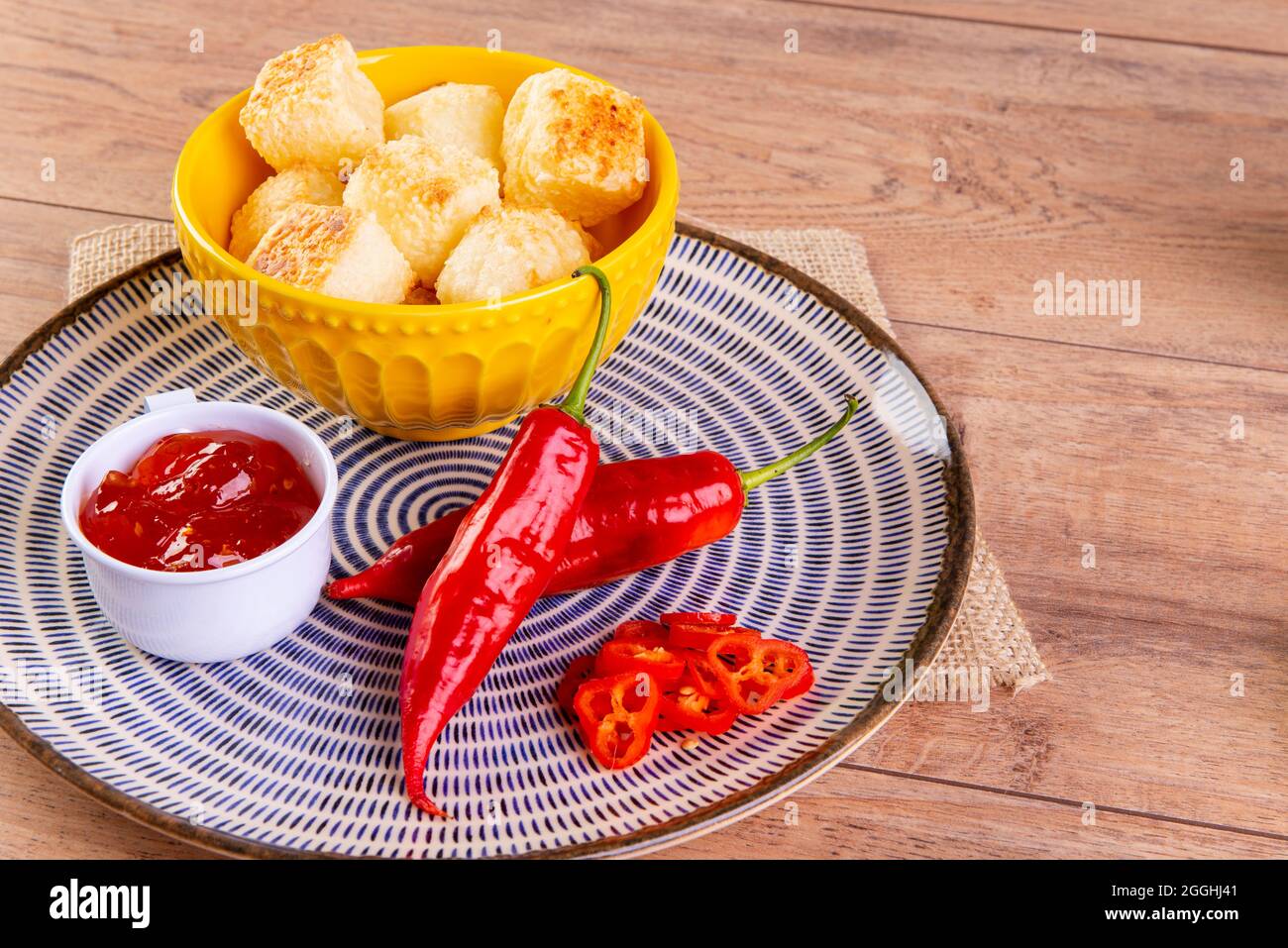 Tapioca dice served with pepper jelly. Wooden table Stock Photo - Alamy