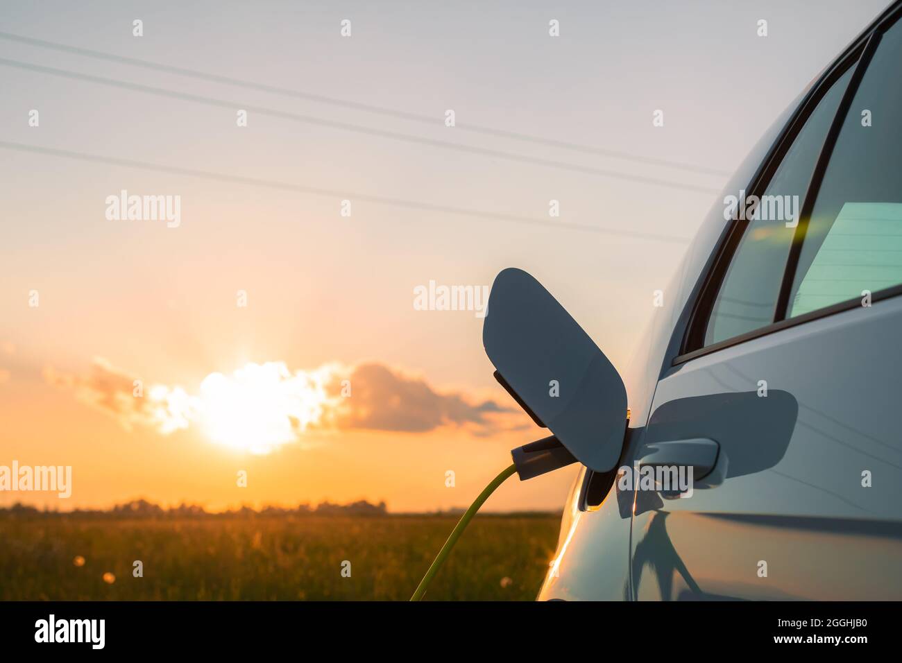 Close up shot of an opened electric car charging socket cap and charger ...