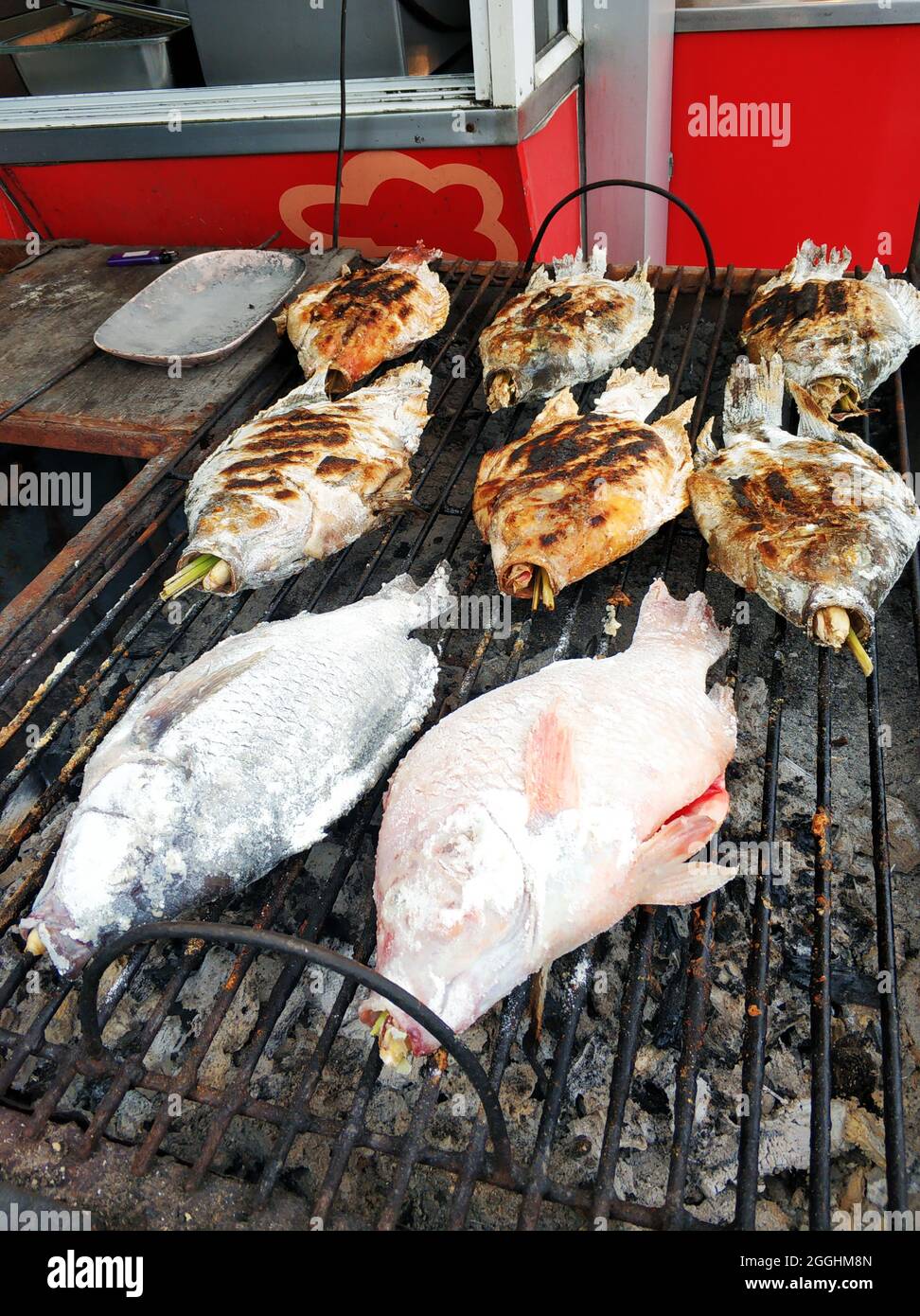 Fresh fish is grilled at the fish market Stock Photo - Alamy