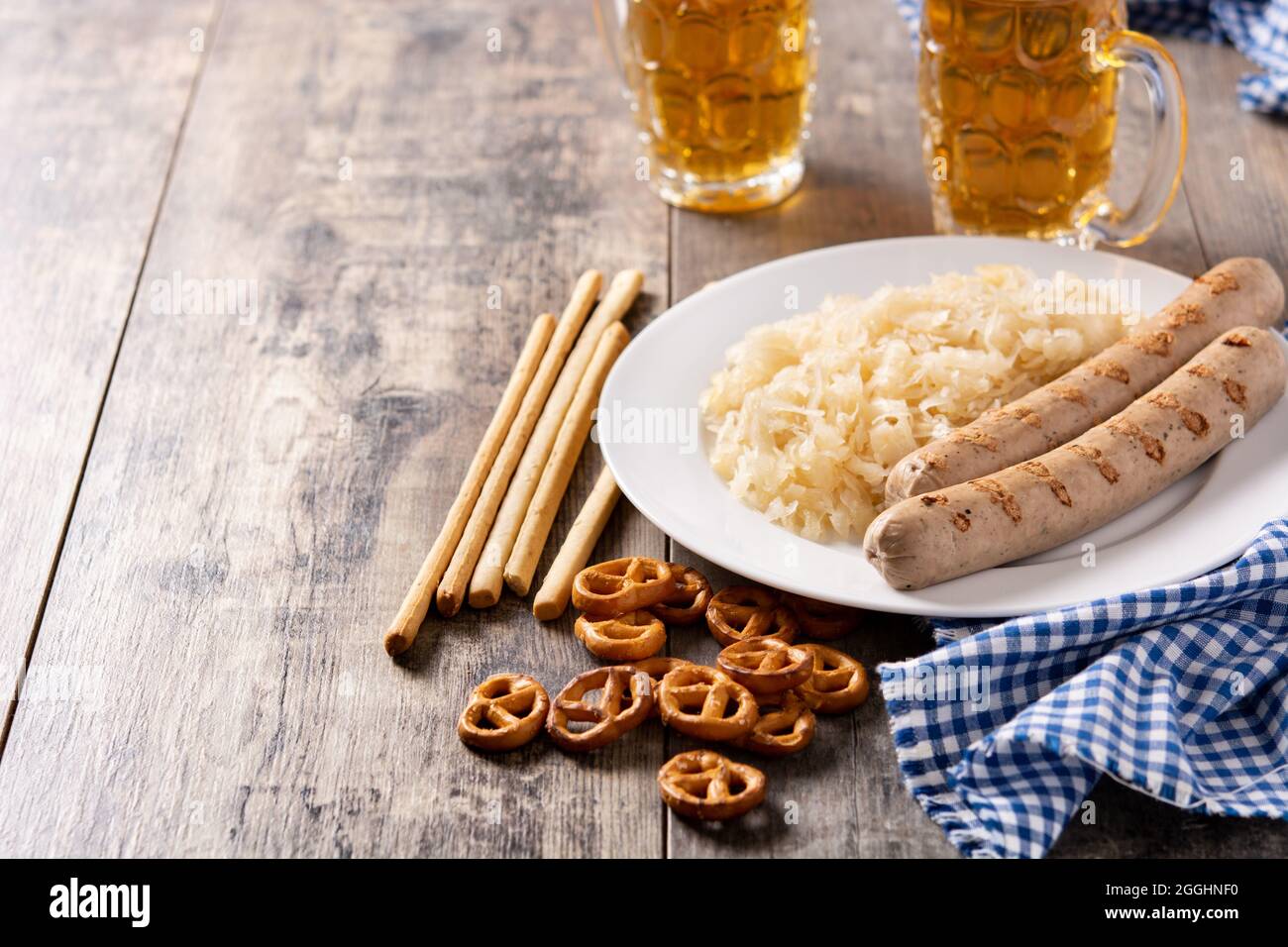 Bratwurst sausage ,sauerkraut, pretzels and beer on wooden table Stock ...