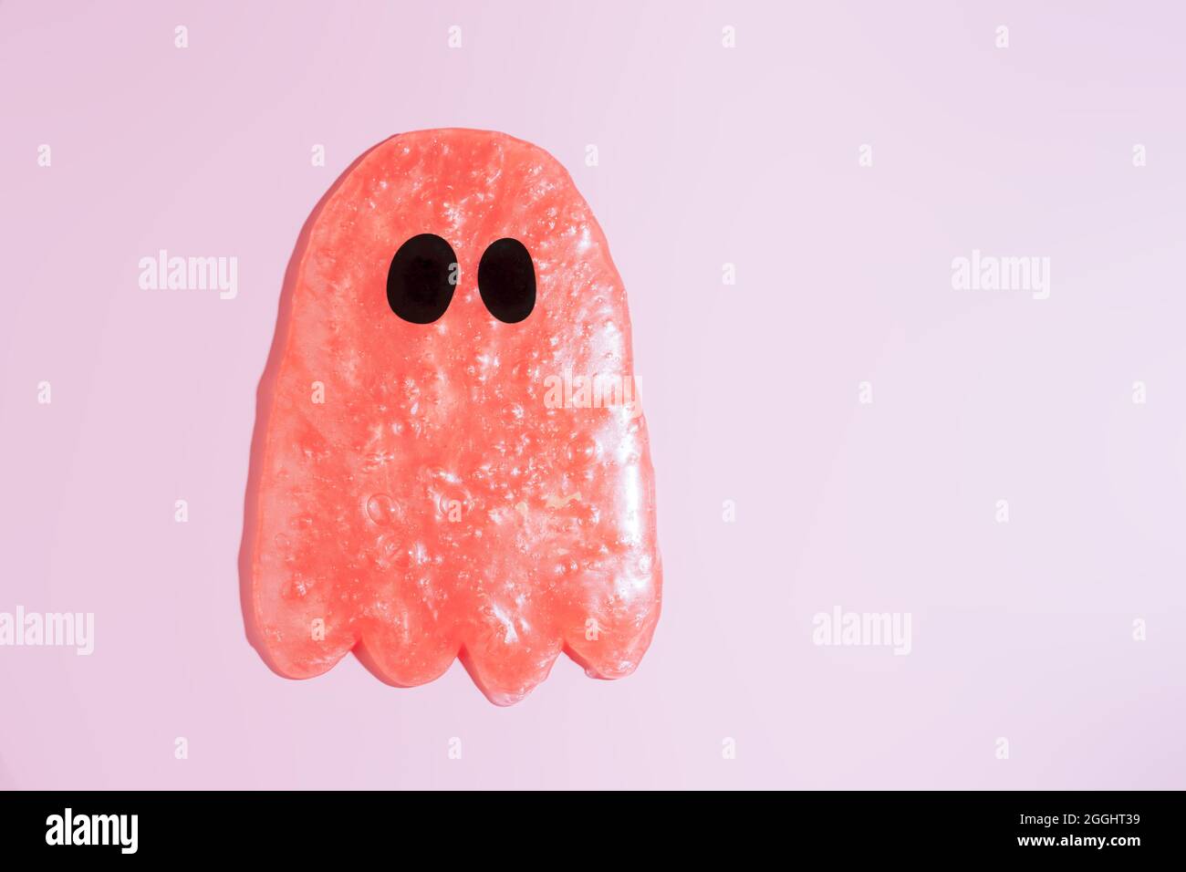 Pink slime ghost with black eyes against pink background Stock Photo ...