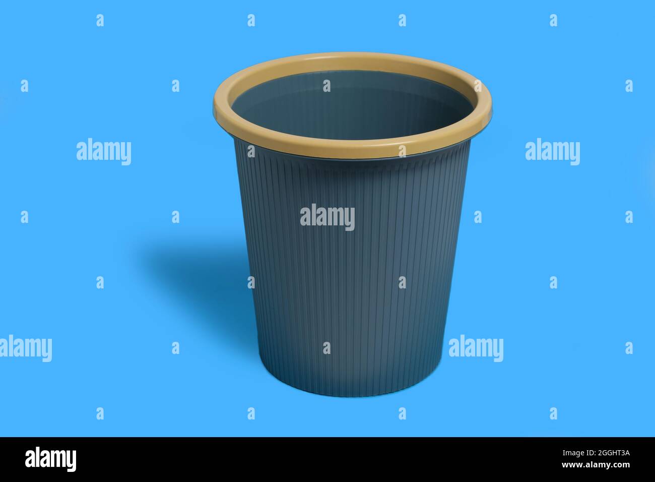 Dark blue garbage bucket on a blue background Stock Photo - Alamy