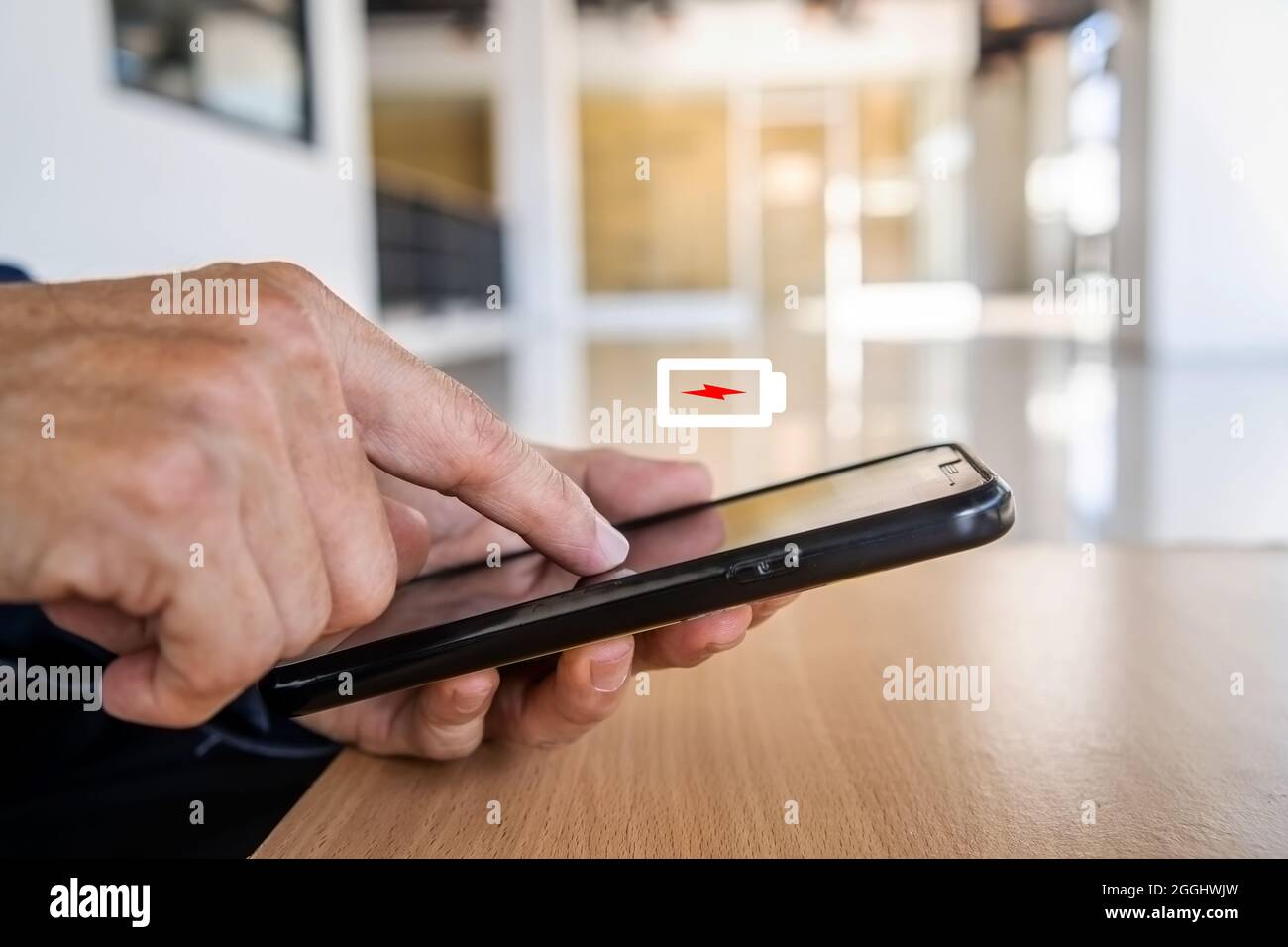 Businessman holding a phone with a low battery charge screen While ...