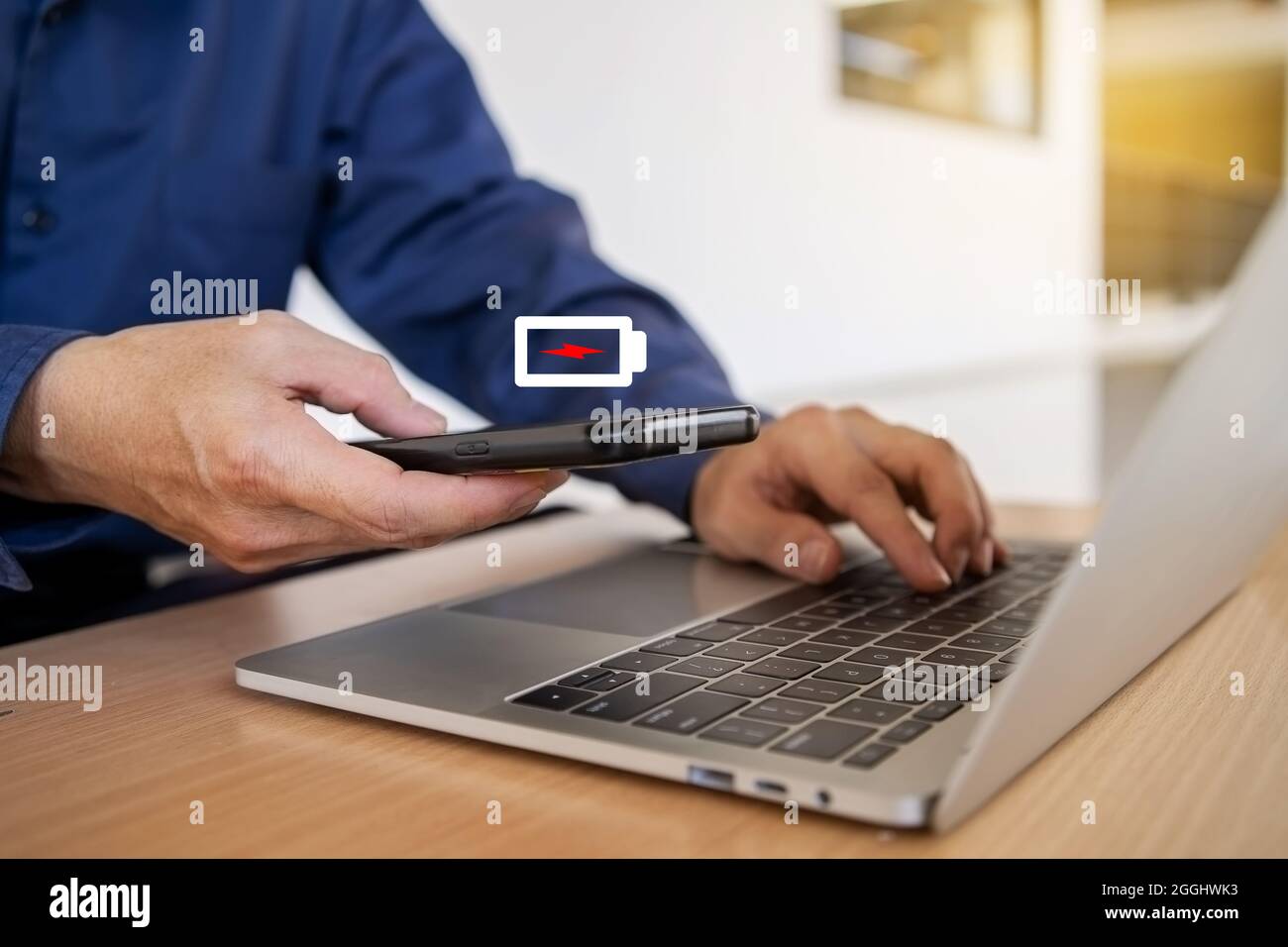 Businessman holding a phone with a low battery charge screen While ...
