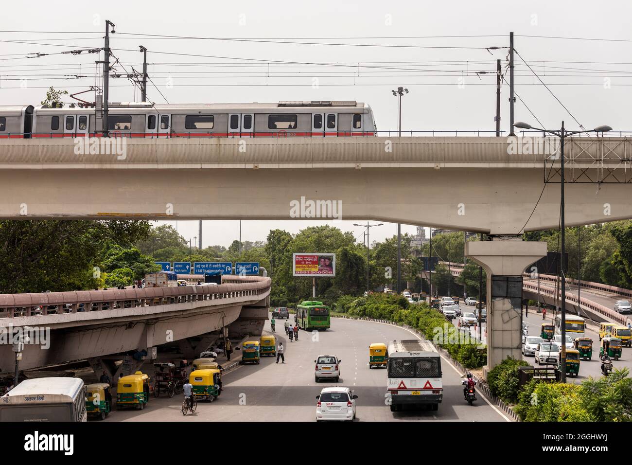 View of a metro train on an elevated track crossing over a busy highway ...
