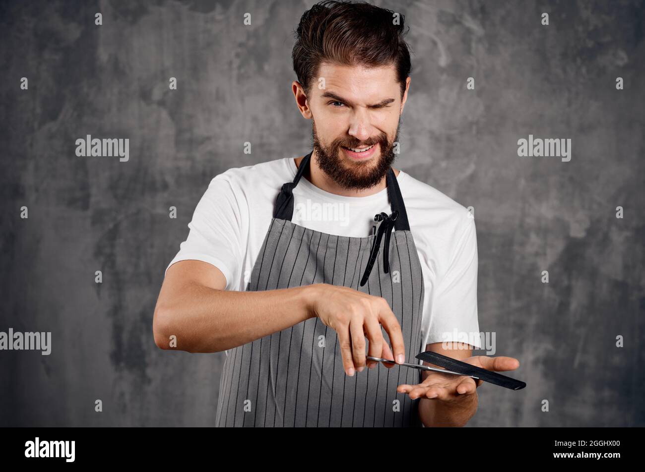 bearded male hairdresser in apron comb scissors service Stock Photo - Alamy
