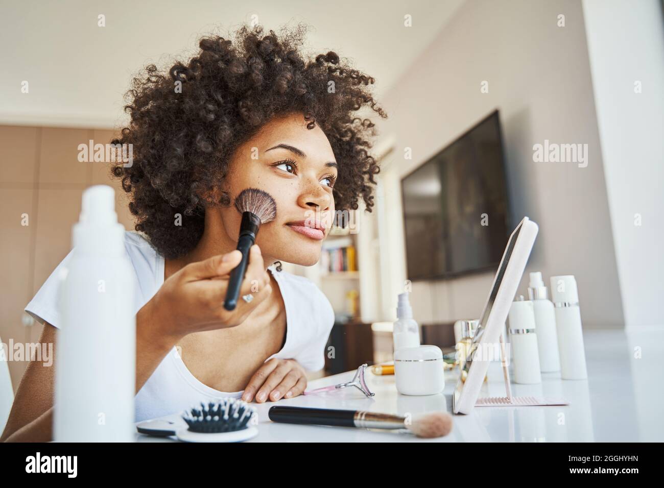 Calm pensive young woman making herself up Stock Photo - Alamy