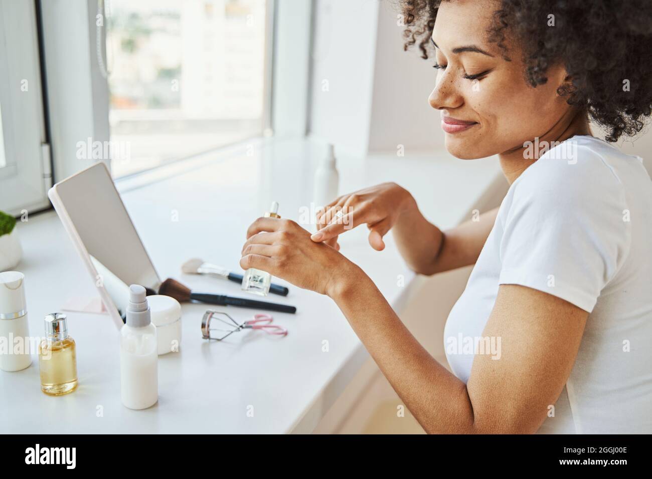 Female using a skincare product from a transparent plastic bottle Stock ...