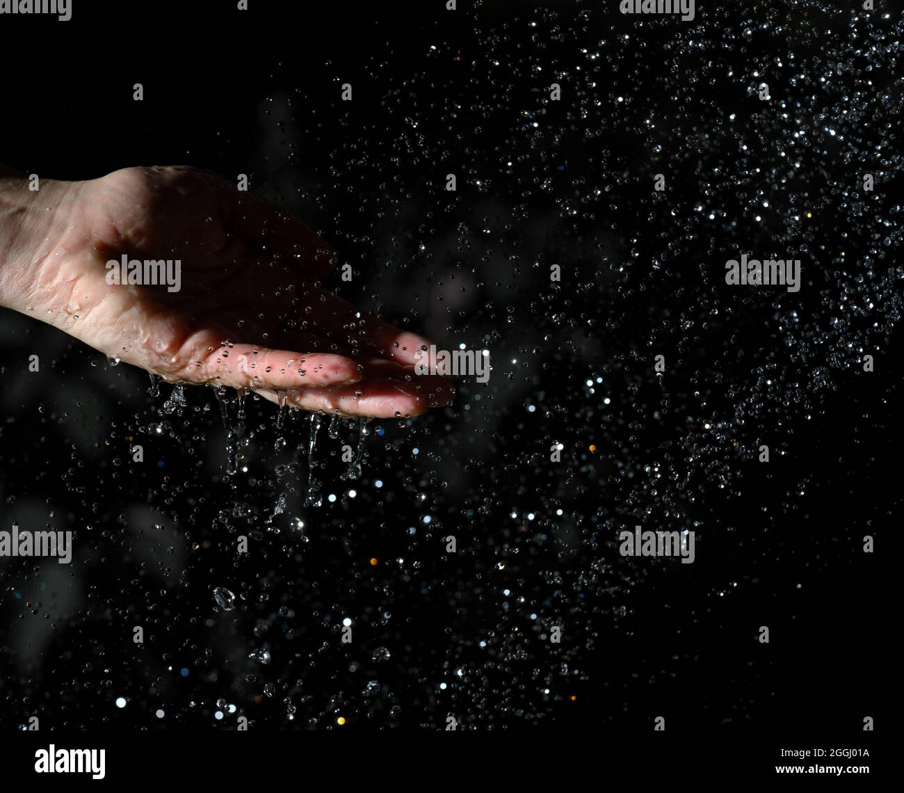 female hand and flying drops of water on a black background Stock Photo ...