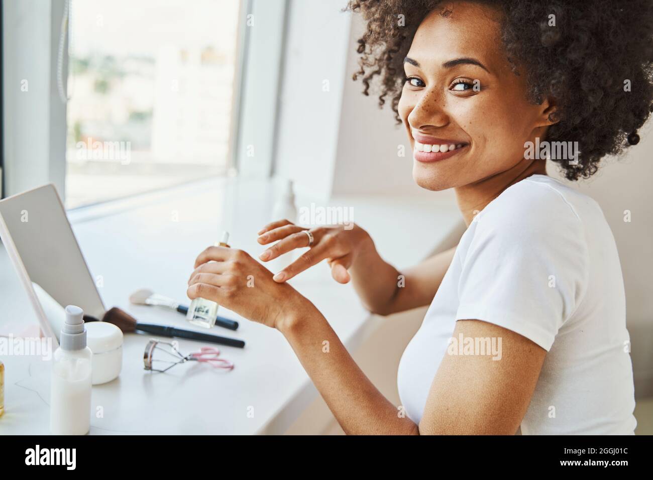 Portrait of a smiling happy beautiful curly-haired lady massaging a ...