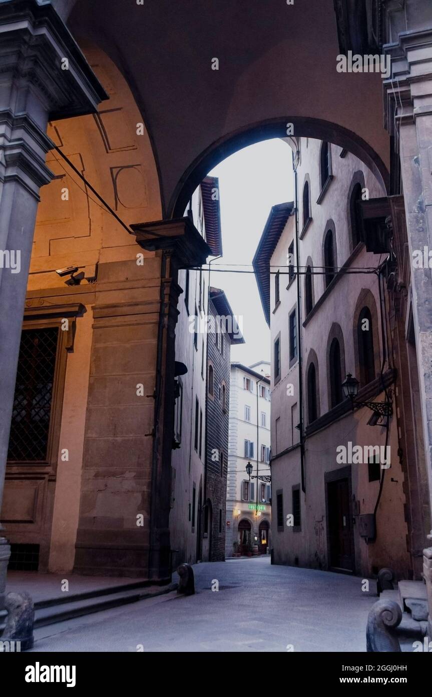 Grand arched portico and narrow winding pedestrian roads of Florence ...