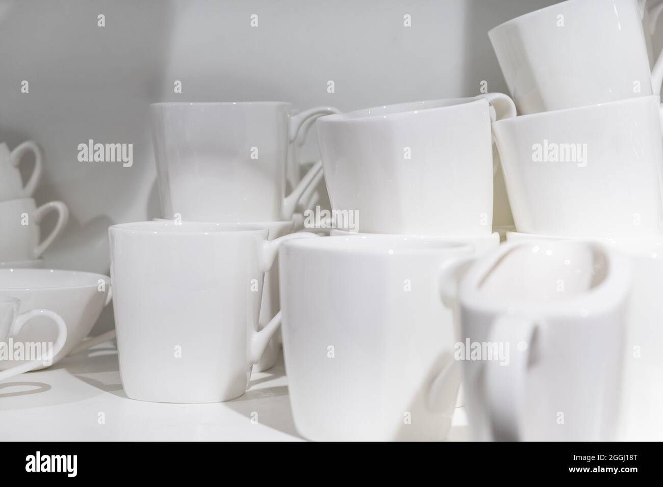 Clean and Empty drinking white ceramic cups mugs in the kitchen cabinet ...