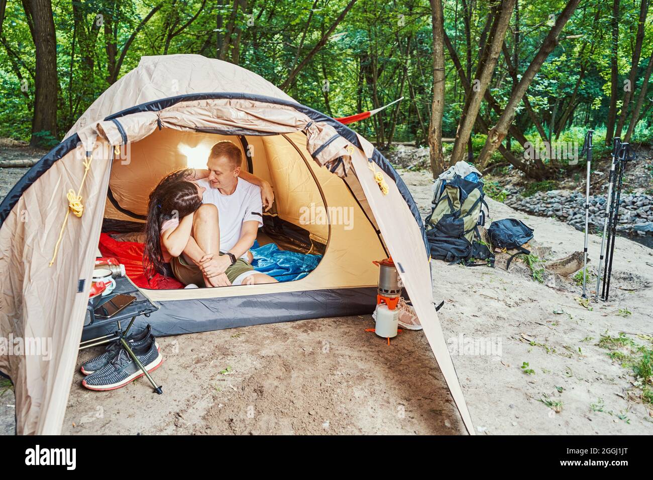 Joyful man and woman in love are spending romantic moments in tent ...