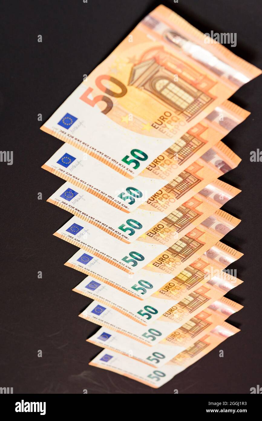 Diagonal line of euro notes isolated on black background, salary in ...