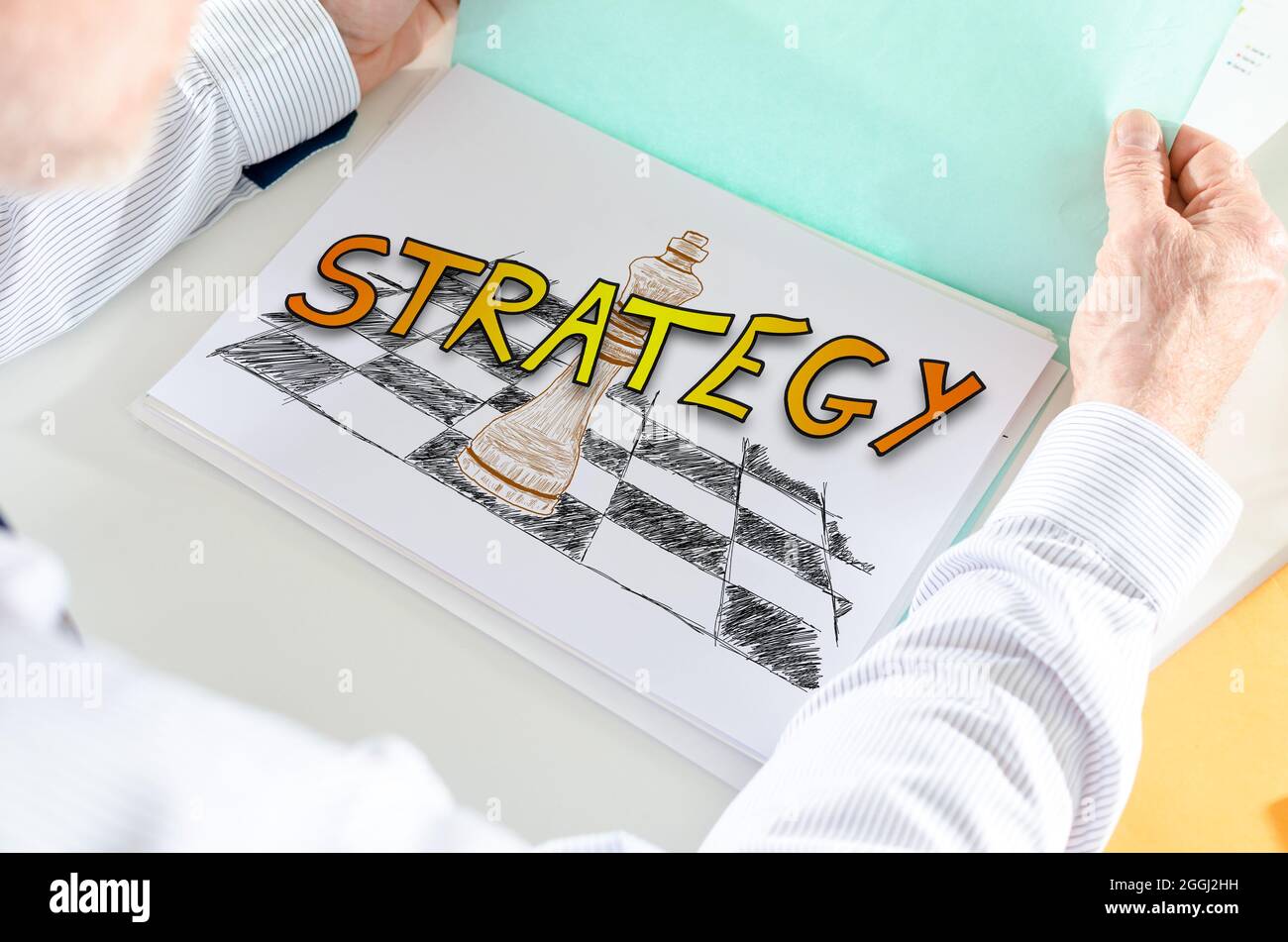Man holding a file with strategy concept Stock Photo - Alamy