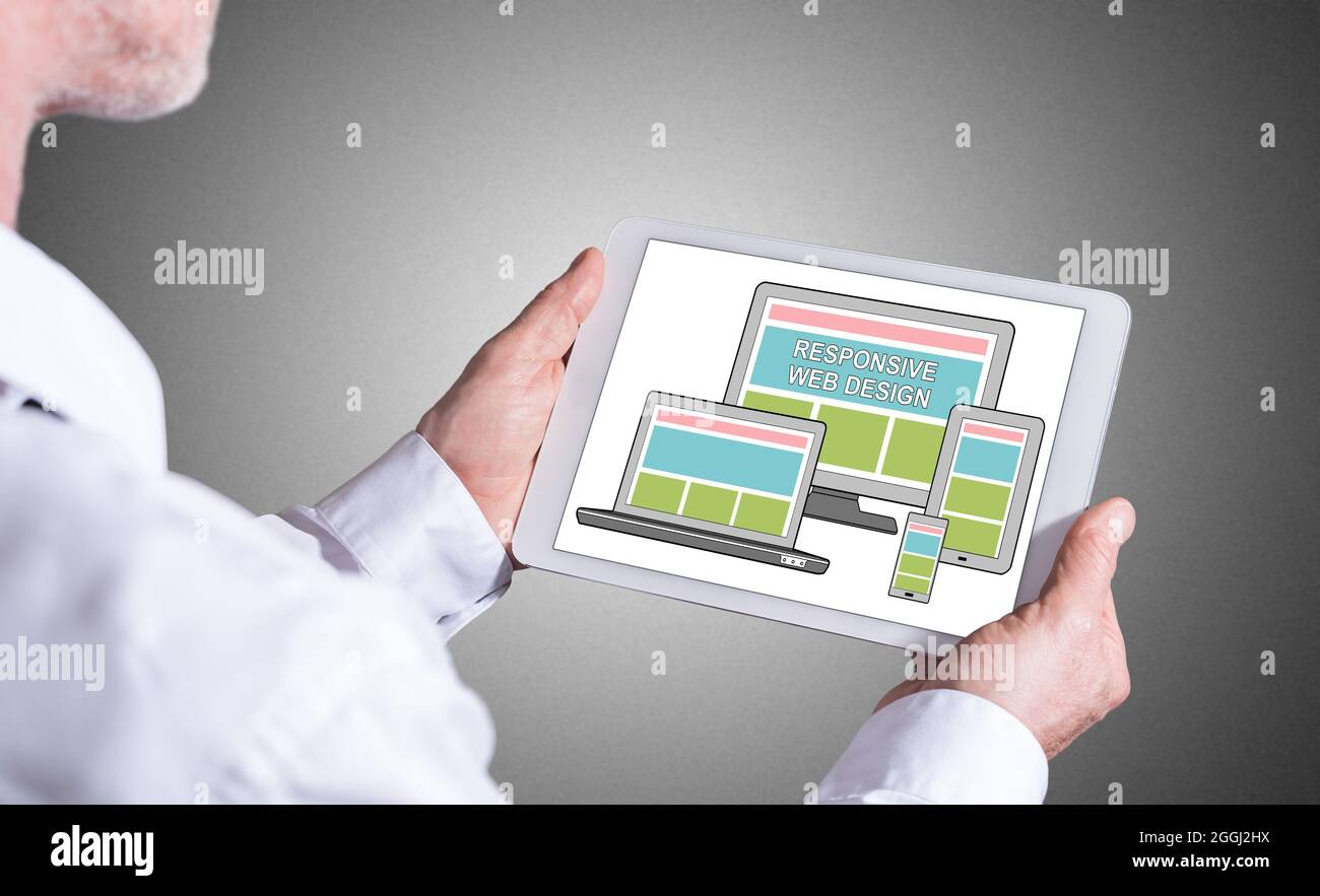 Man holding a tablet showing responsive design concept Stock Photo - Alamy
