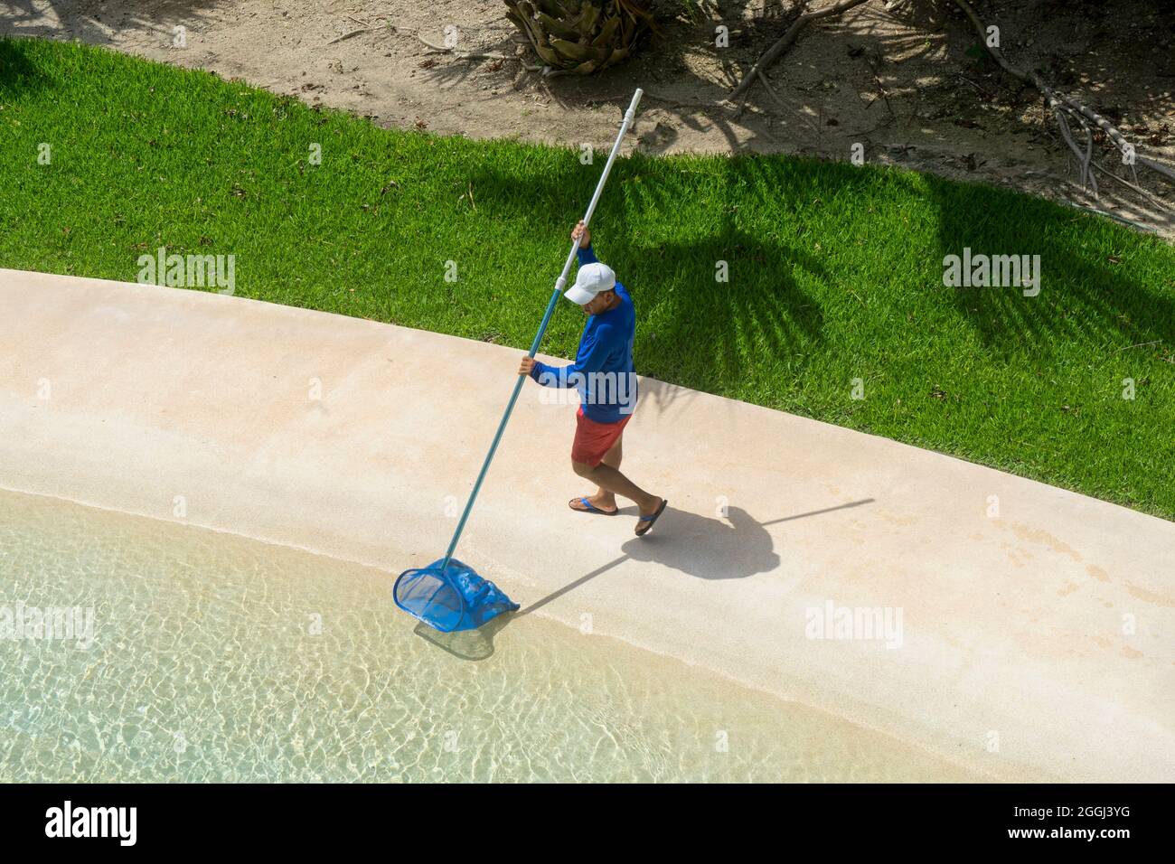 A Young Latino Man, Cleans a Pool in a Garden in Mexico Stock Photo - Alamy