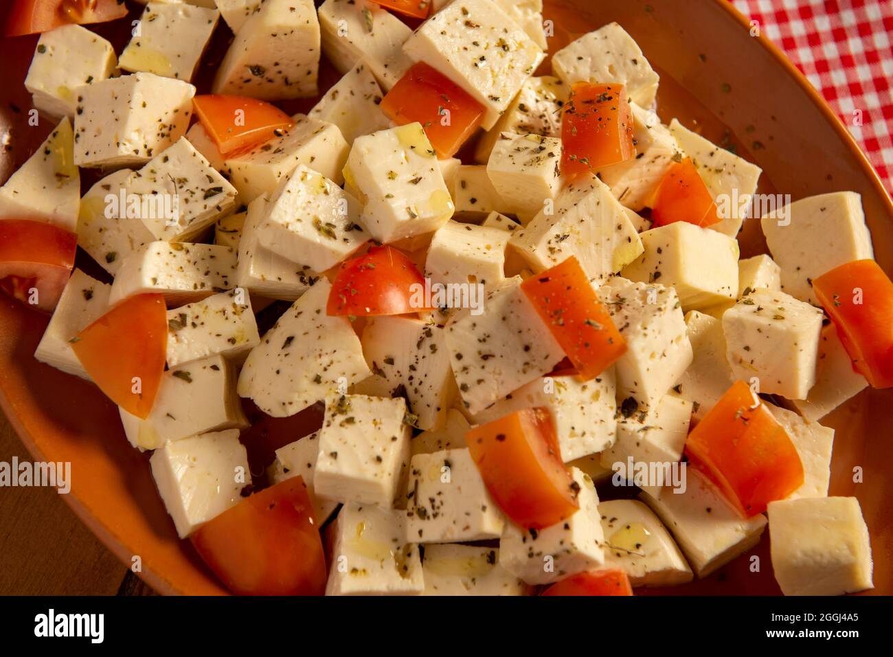 portion of half-cured cheese with chopped tomatoes and seasoned with ...