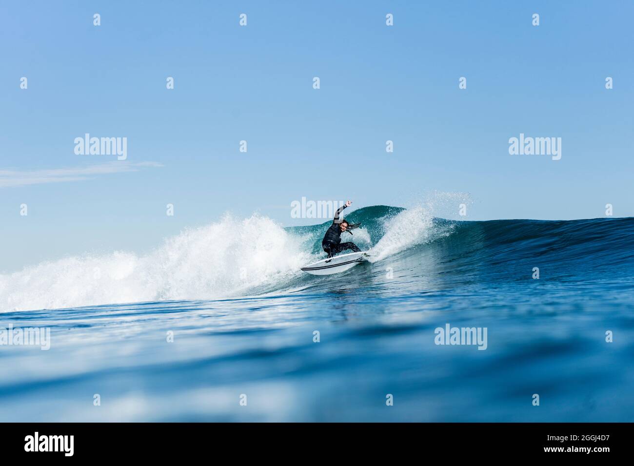 man surfing and doing a surf maneuver on a wave in the sea Stock Photo ...