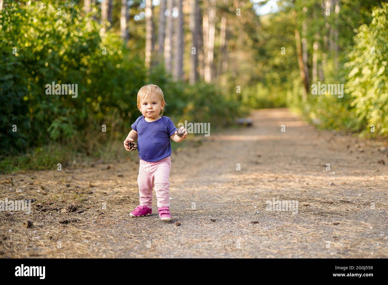 Small child standing on the forest road Stock Photo - Alamy
