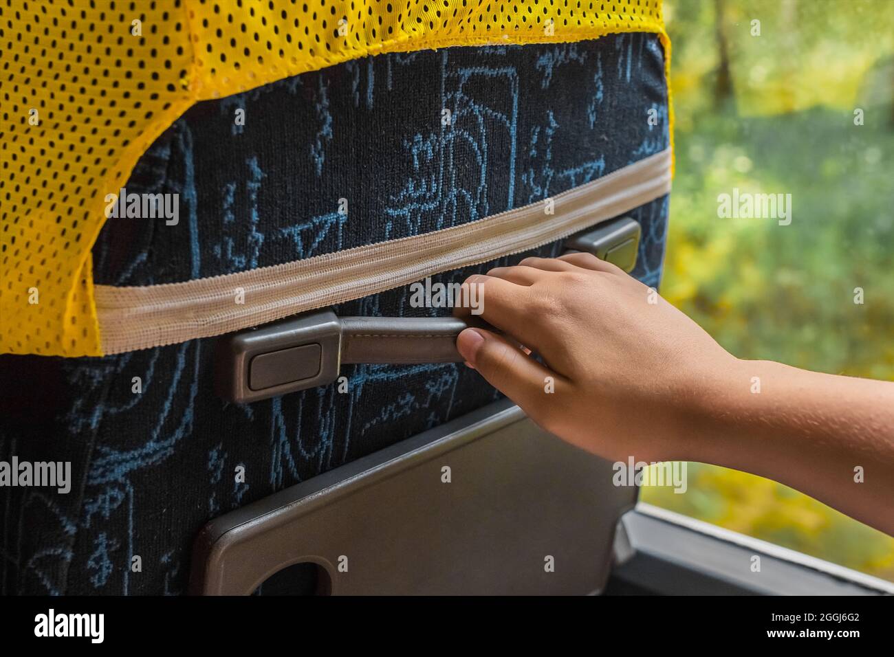 The girl's hand is holding on to the rubber handle of the seat on the ...