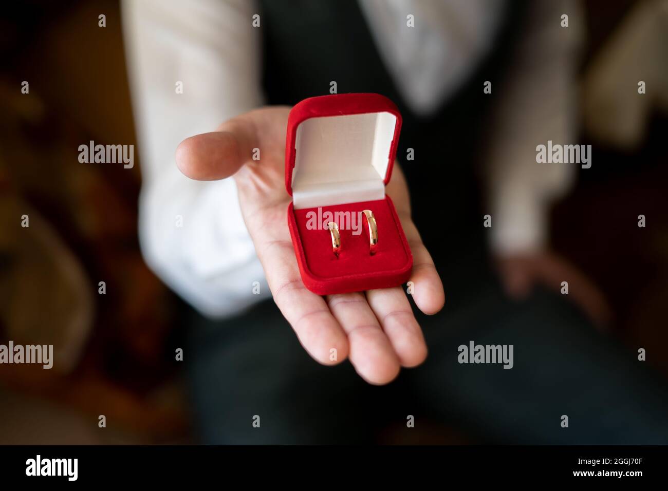 Gold wedding rings in a red box in your hand Stock Photo - Alamy