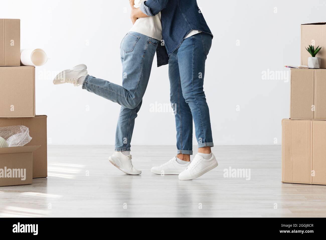 Legs of hugging man and woman standing among moving boxes Stock Photo ...