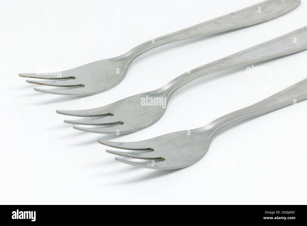 Closeup of three metal forks on white background Stock Photo - Alamy