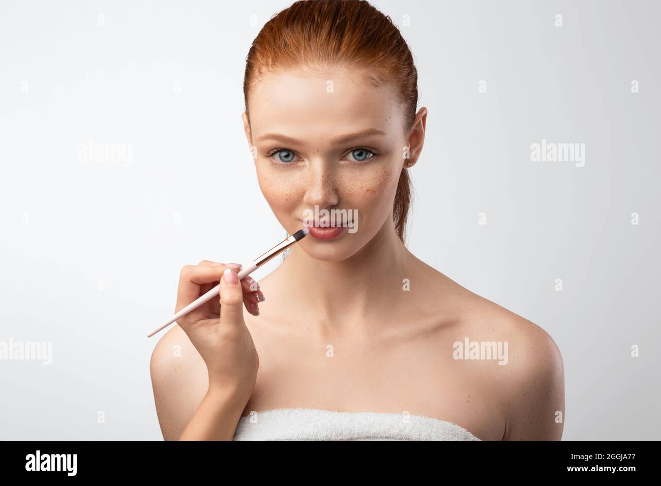 Female Arm Making Makeup For Red-Haired Female Model, Gray Background ...