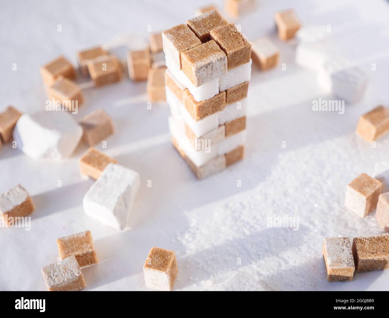 A tower of white and brown sugar cubes. Sweet food ingredient concept ...