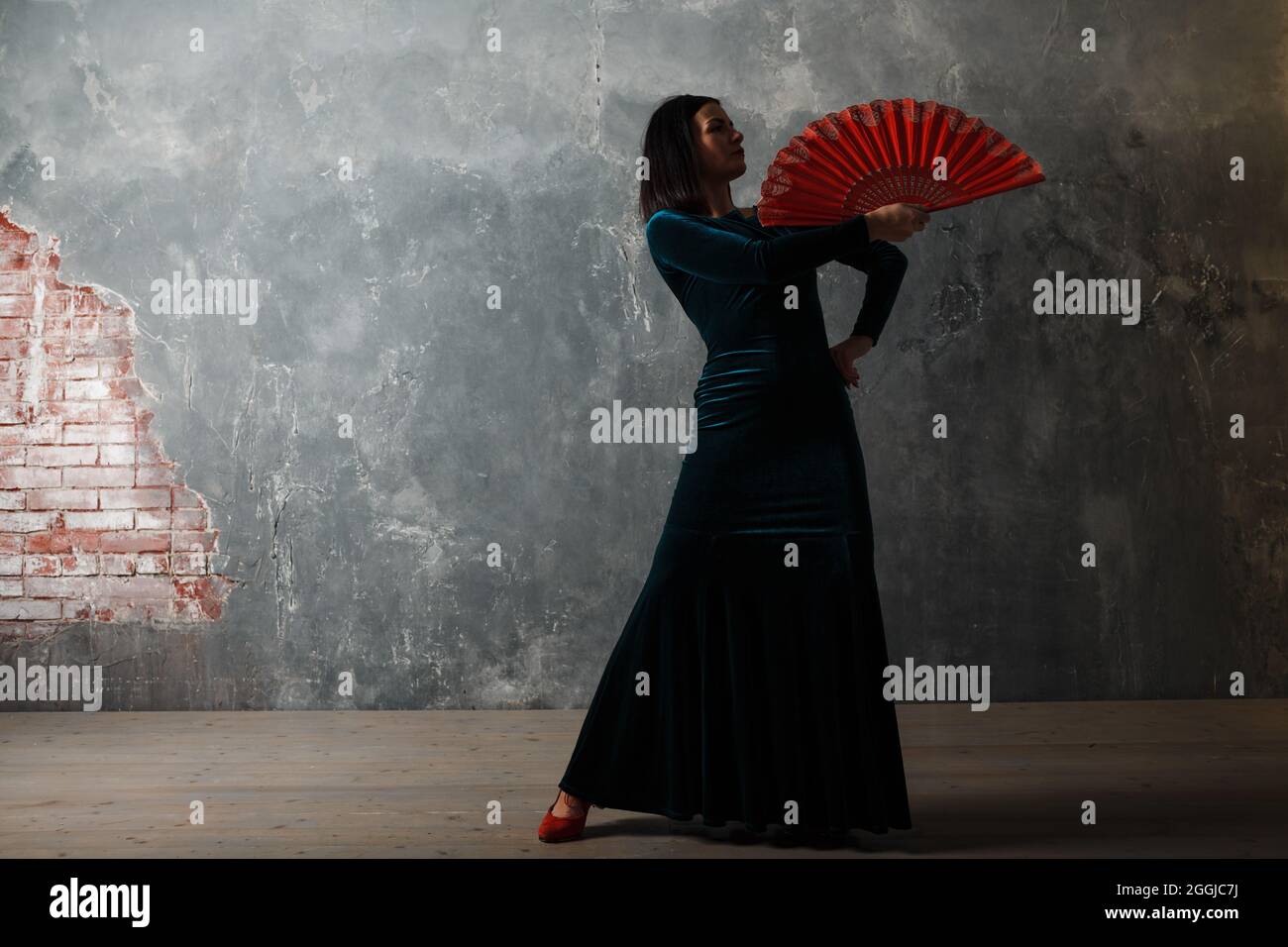 Young adult spanish woman dancing flamenco on gray vintage studio ...