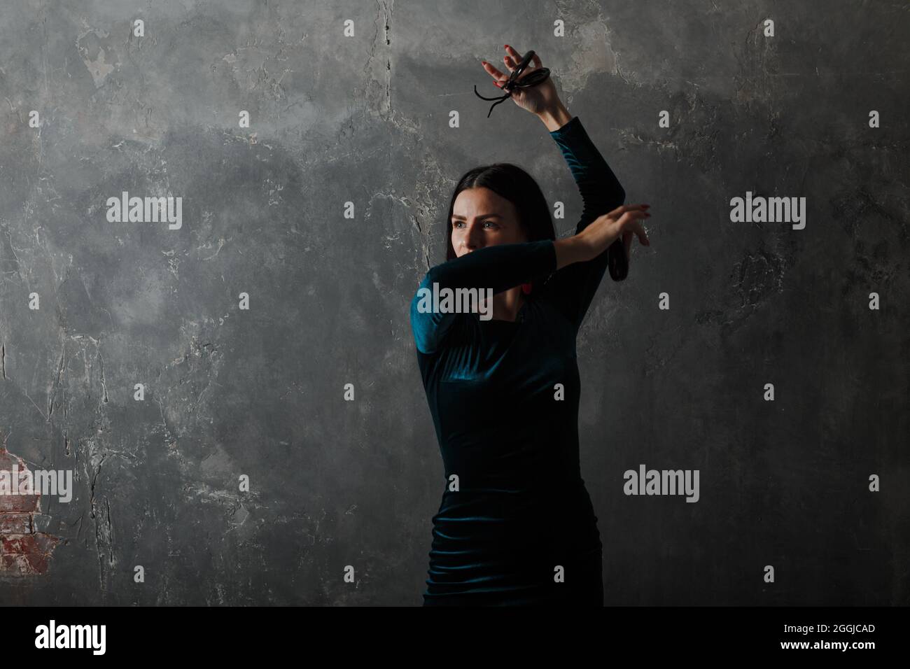 Young adult spanish woman dancing flamenco on gray vintage studio ...
