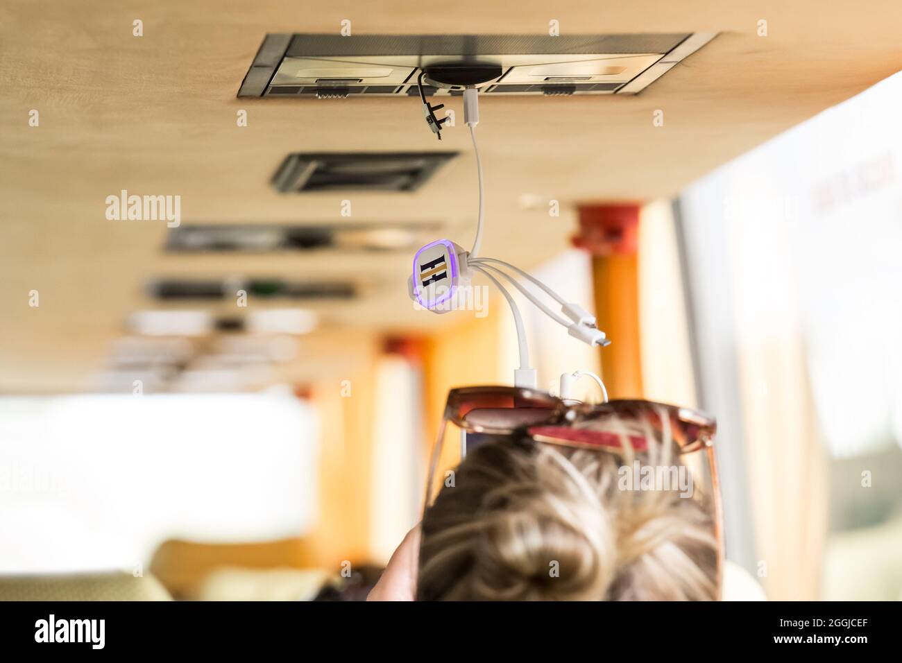 The girl charges the phone in the bus with the help of a modern device ...