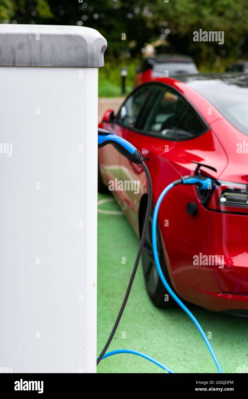 Electric car charging at plug in charge station in a public car park in ...