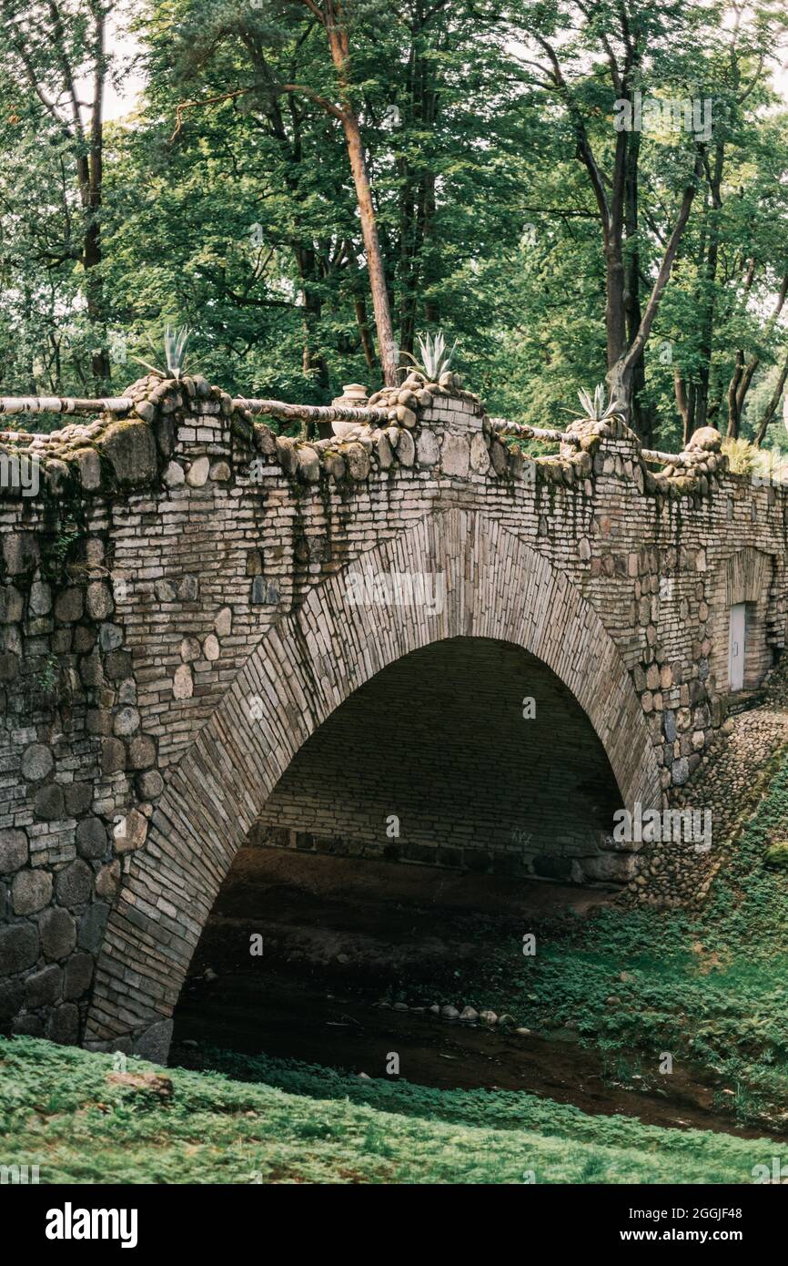 Beautiful old stone bridge in summer park Stock Photo - Alamy