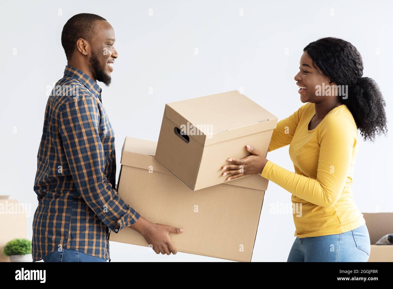 Happy Black Spouses Moving To New Apartment, Carrying Belongings In ...