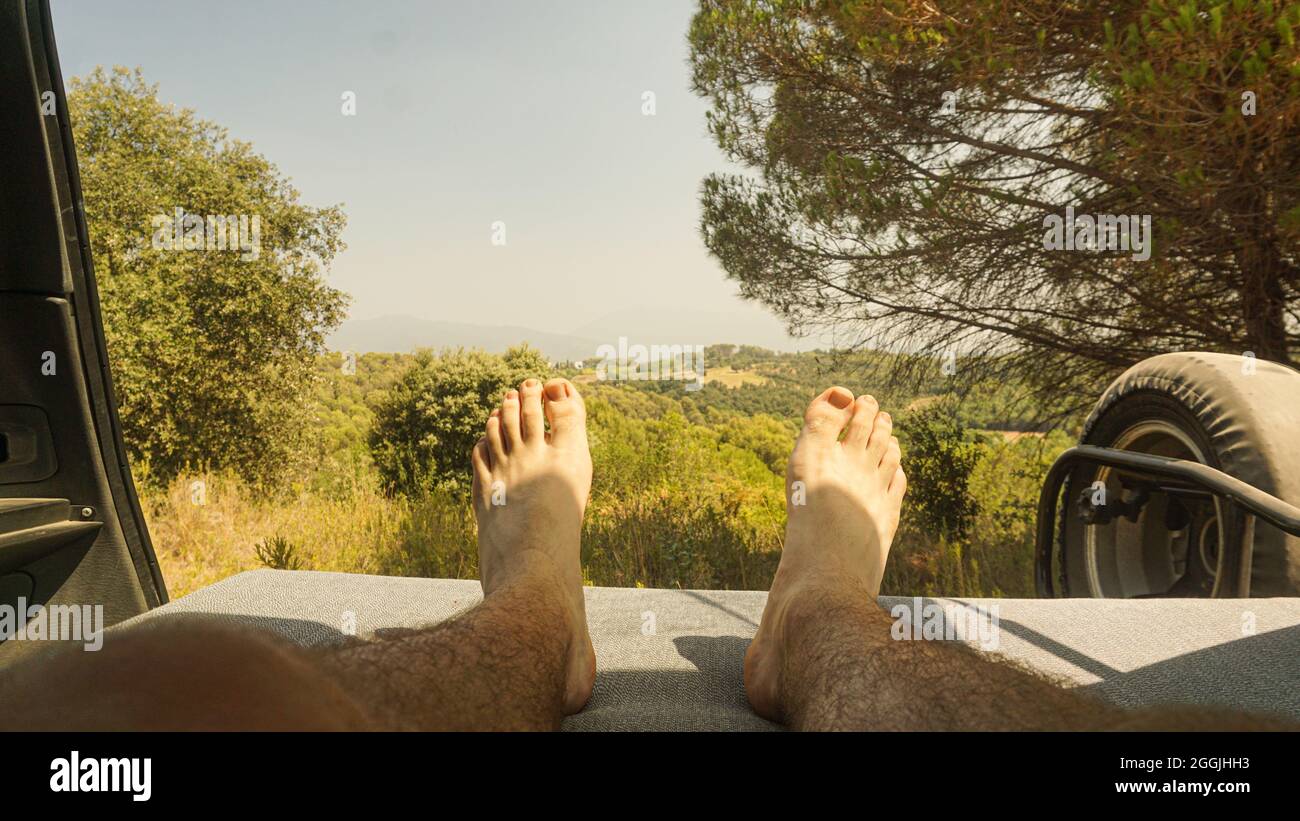 Male laying and relaxing in the truck of a van under a sunny sky Stock ...