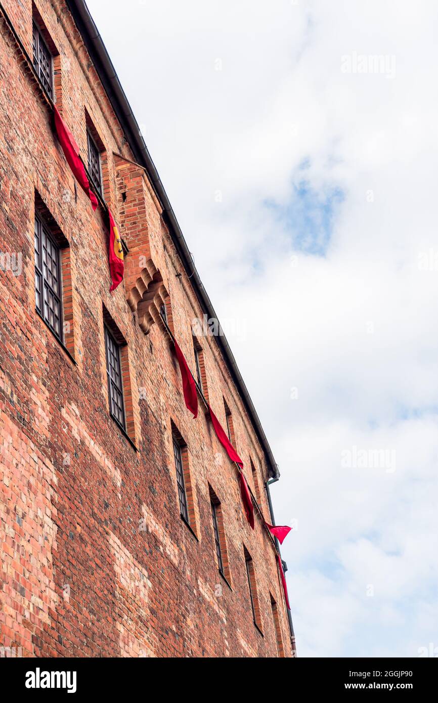 Gothic castle wall built of brick, flags attached to the wall, castle ...