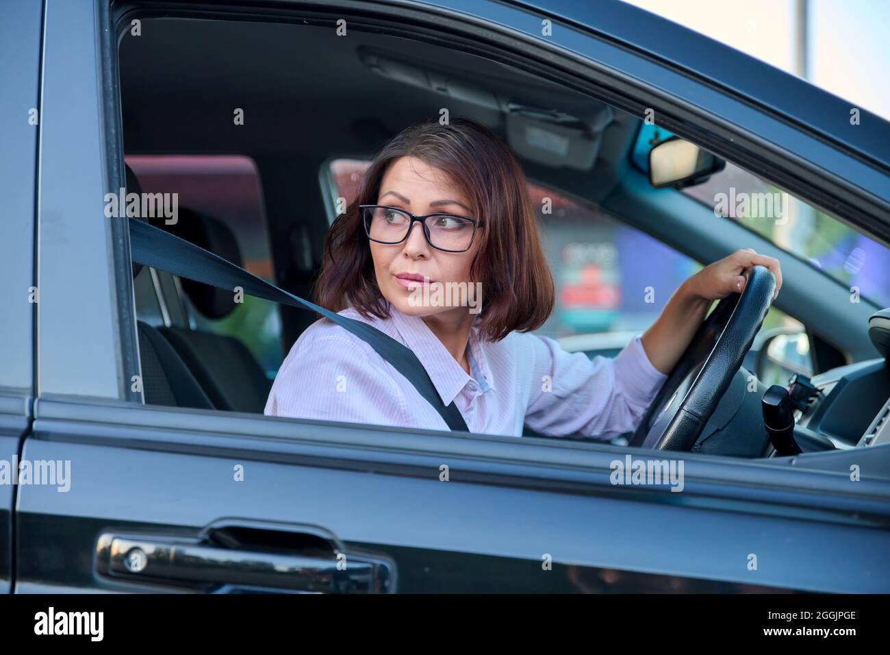 Middle-aged beautiful woman driver driving a car Stock Photo - Alamy
