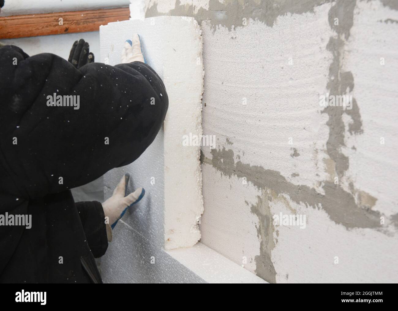 Builder installing rigid styrofoam insulation board for energy saving ...