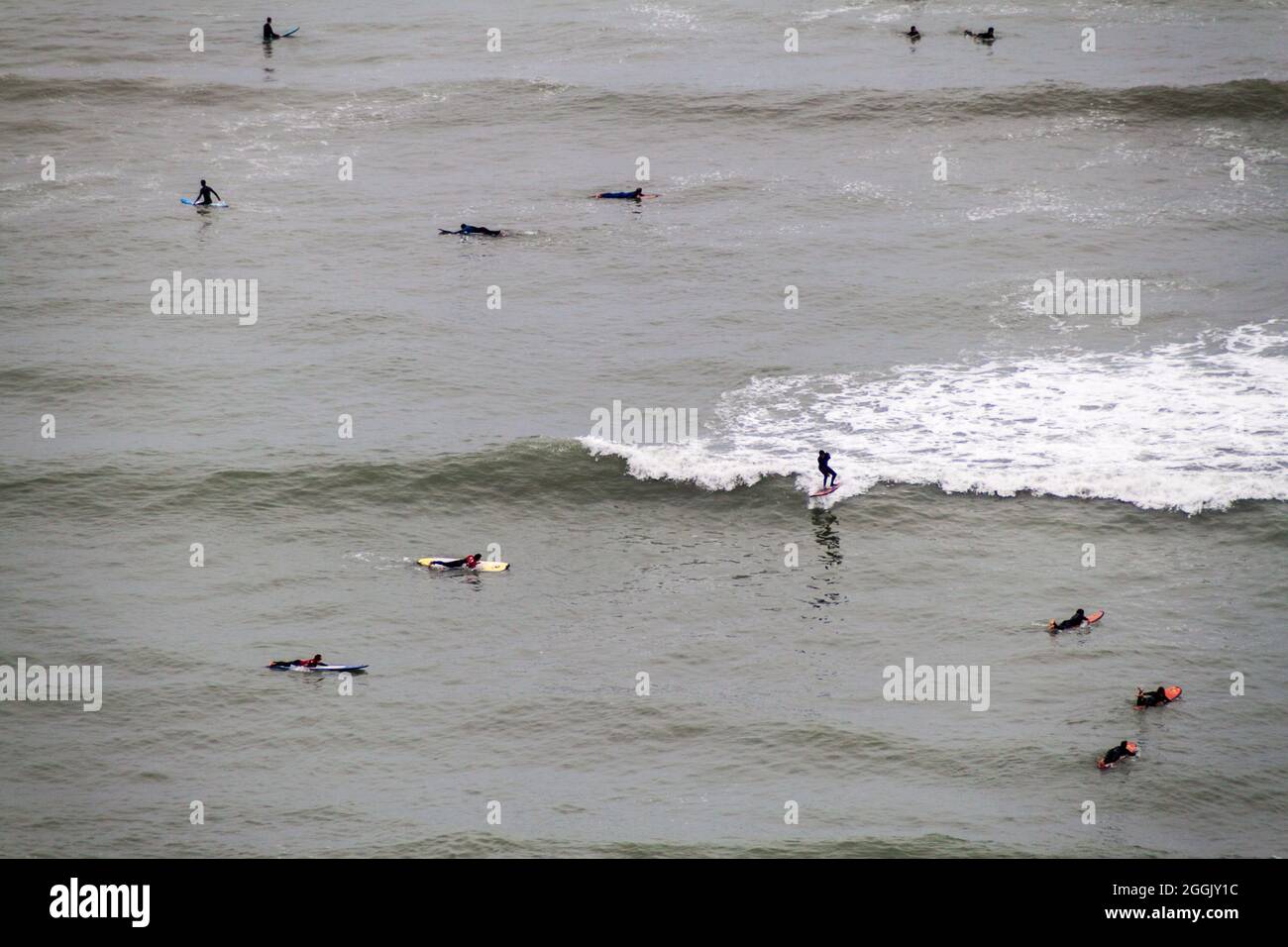 LIMA, PERU - JUNE 4, 2015: People surf on waves of an ocean. Miraflores ...