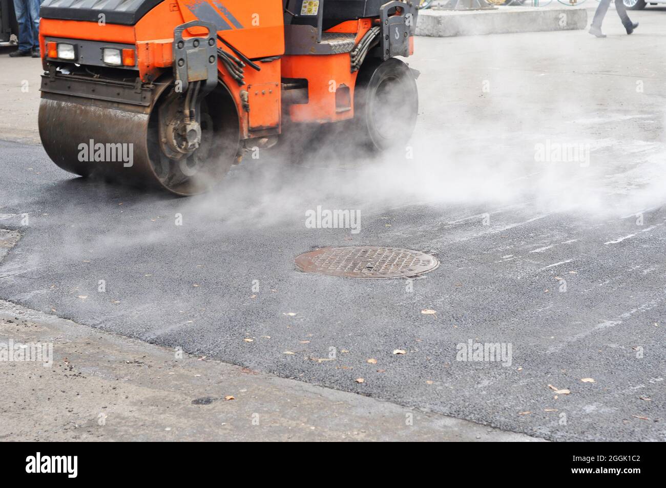 Road repair, compactor lays asphalt. Repair pavement and laying new ...