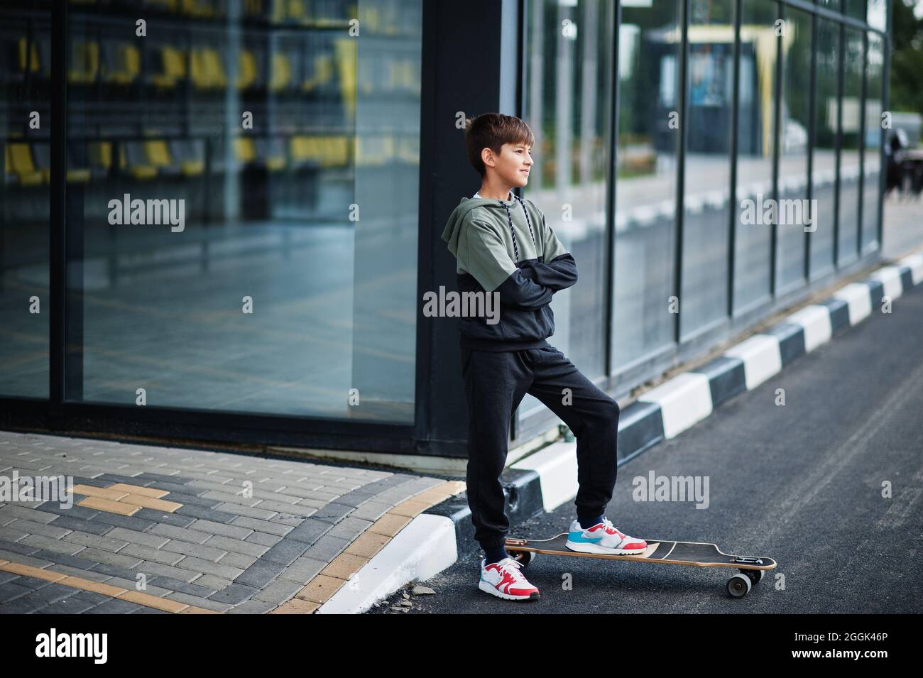 Teenager boy in a sports suit with longboard Stock Photo - Alamy