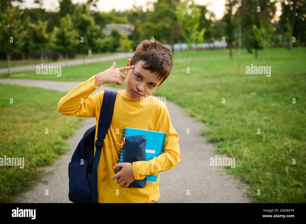 A schoolboy, gives out, looking at camera with tired eyes, brings his ...