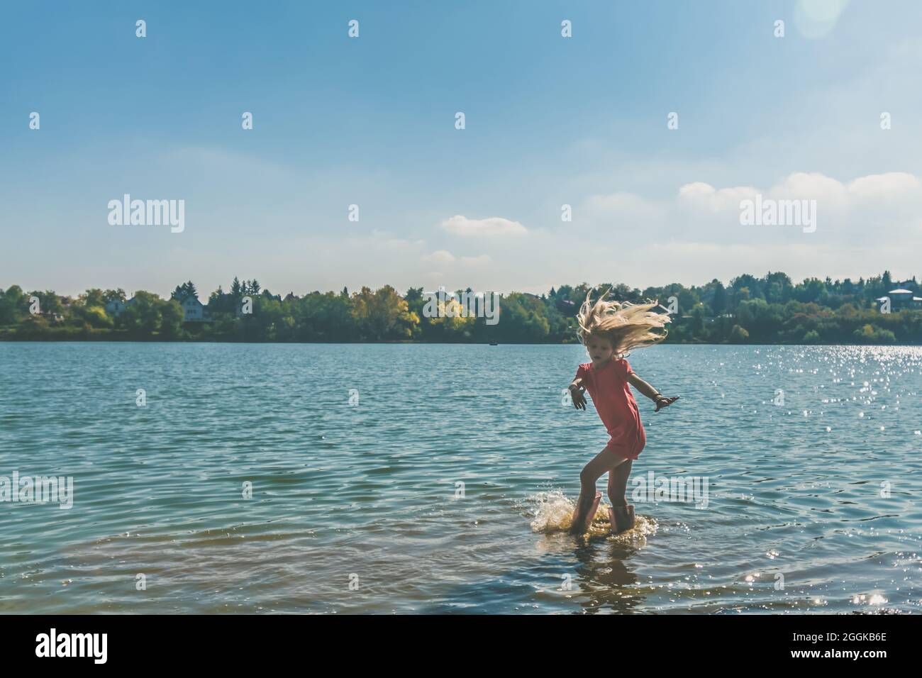 one child splashing water while running in the water Stock Photo - Alamy