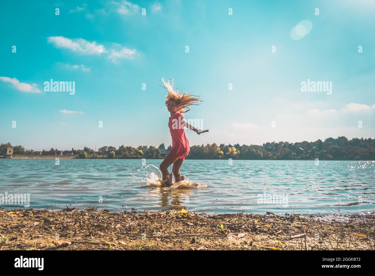 one child splashing water while running in the water Stock Photo - Alamy
