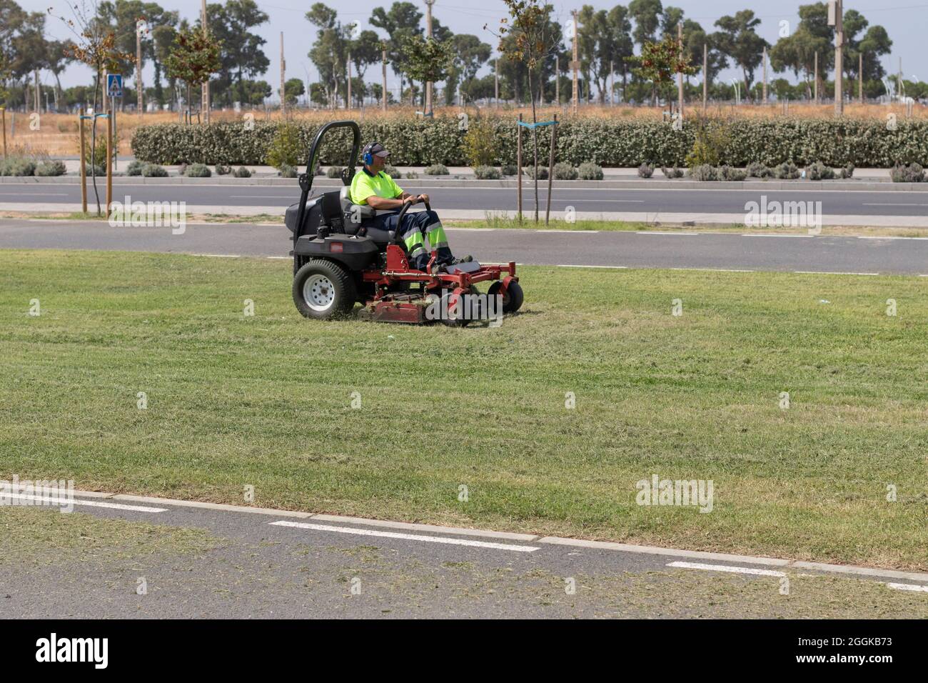 a man driving a lawn mower. Maintenance concept Stock Photo - Alamy