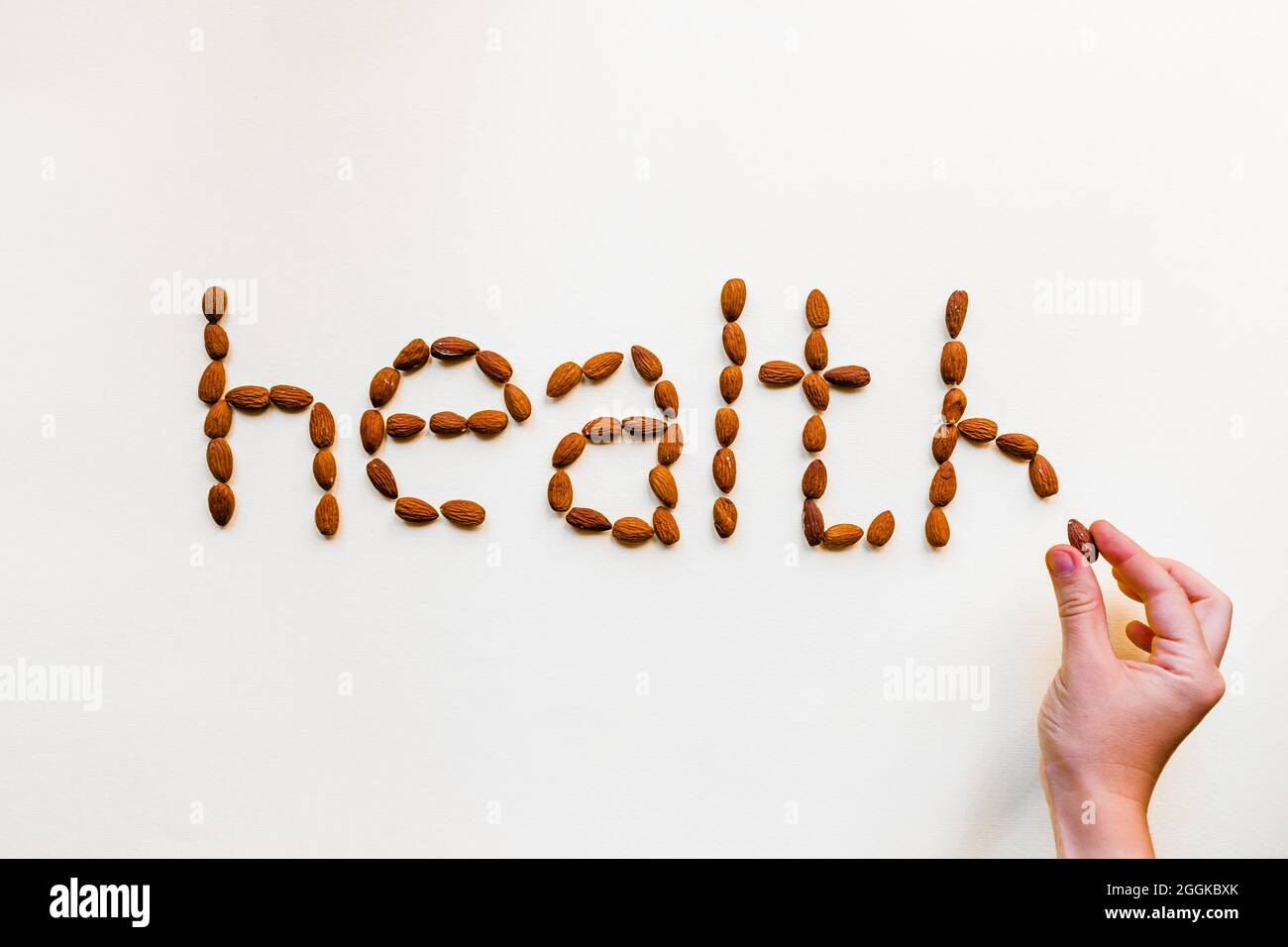 The word health laid out from almonds on a white background Stock Photo ...
